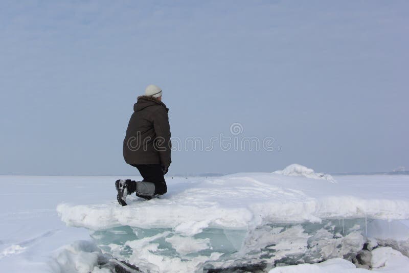 The Man in a Gray Cap Sitting on an Ice Block Looking Afar Stock Photo ...
