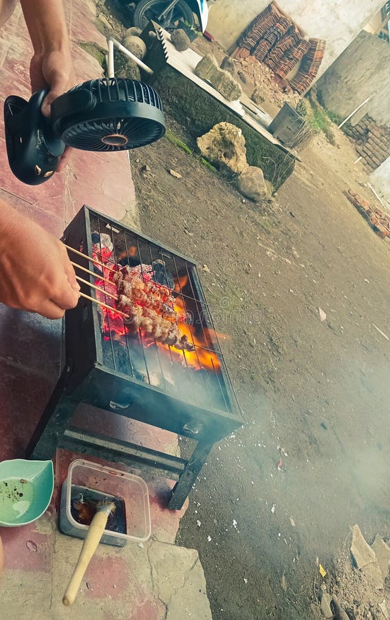 A Man is Grilling Beef Satay Using a Fan in His Left Hand Stock Image ...