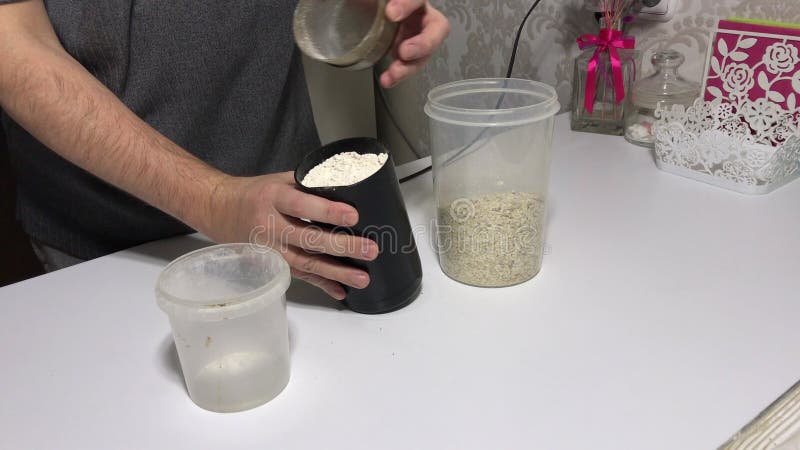 A Man Grinds Oatmeal into Flour. Using a Coffee Grinder Stock Footage ...