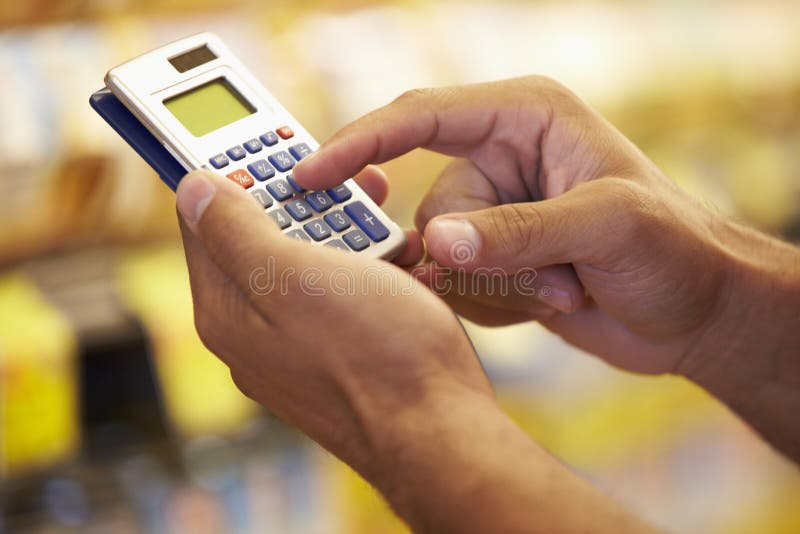 Man in Grocery Aisle of Supermarket Using Calculator Stock Photo ...