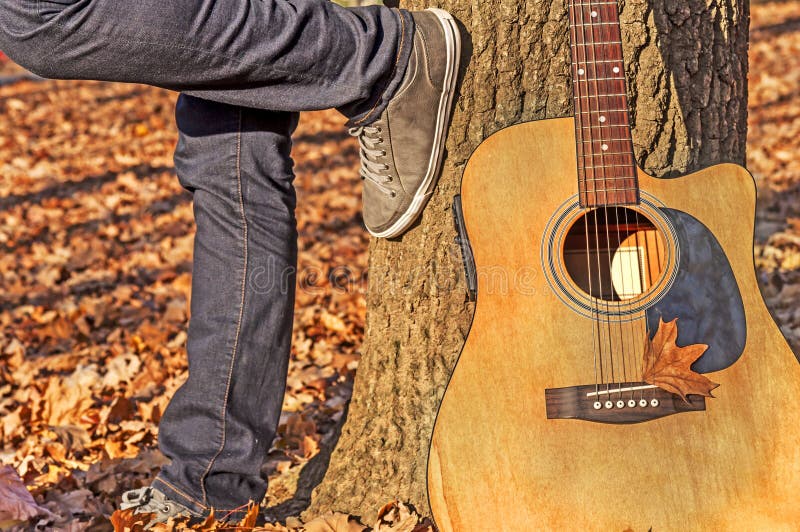 Man and Guitar Leaning on a Tree in Autumn Park Stock Photo - Image of ...