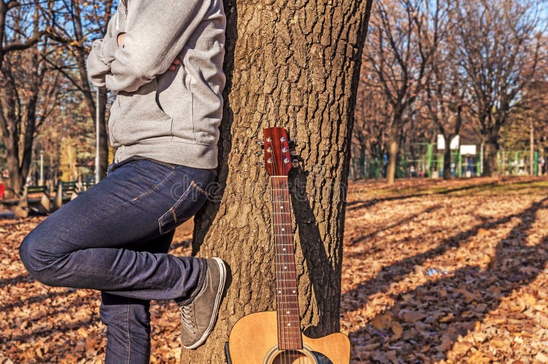 Man and Guitar Leaning on a Tree in Autumn Park Stock Image - Image of ...
