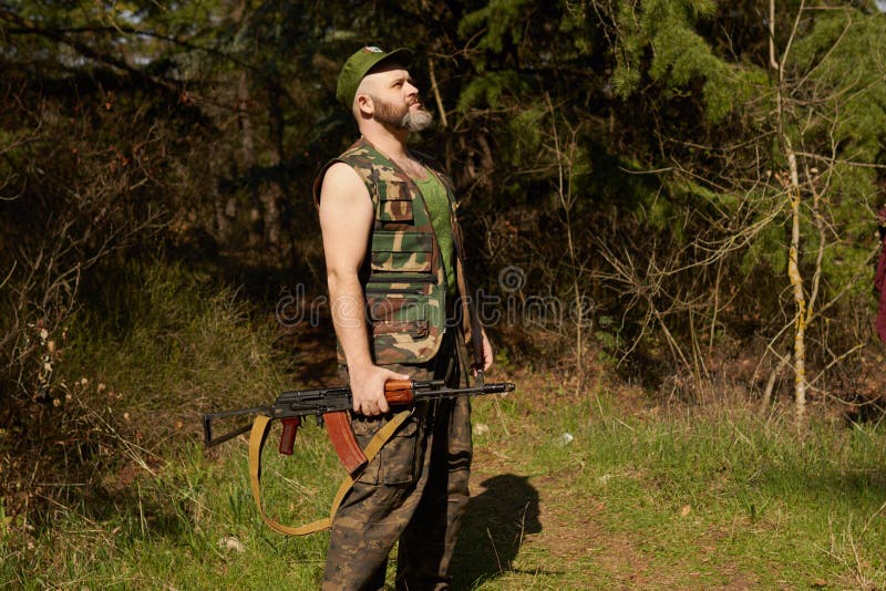 A Man with a Gun in a Forest Stock Photo - Image of survival, forest ...