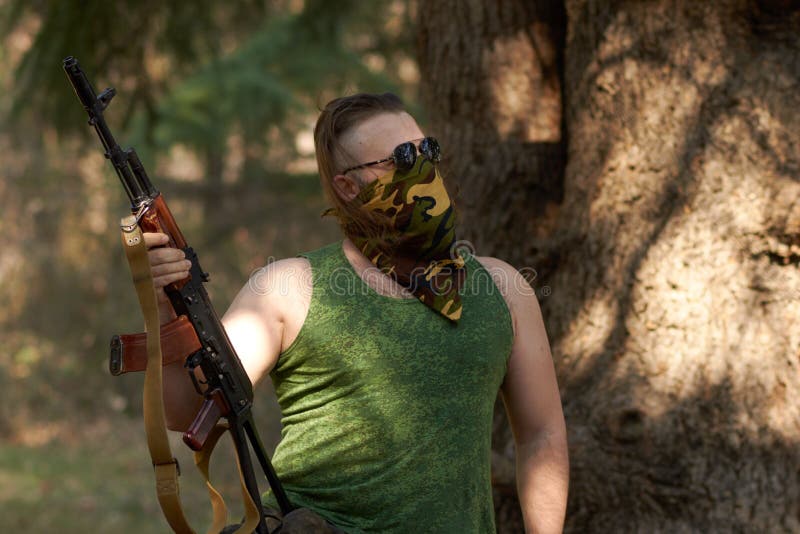 A Man with a Gun in a Forest Stock Photo - Image of hunter, handgun ...