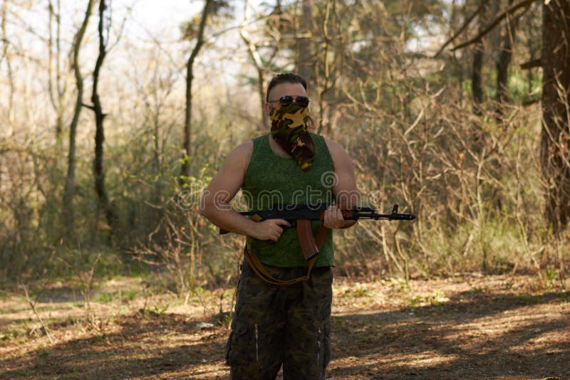 A Man with a Gun in a Forest Stock Photo - Image of aiming, prey: 185899080