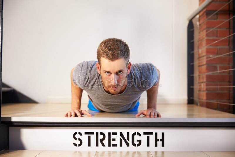 Man in Gym Doing Press-Ups on Step Labeled Strength Stock Photo - Image ...