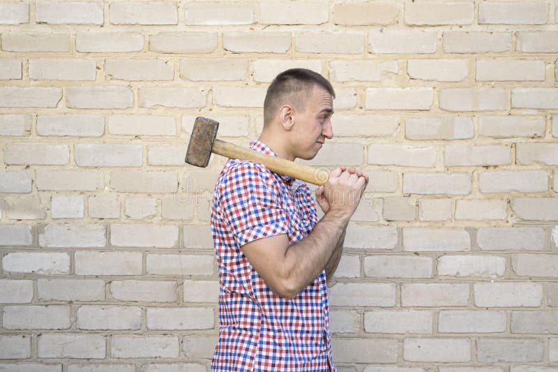 Man with a Hammer on the Shoulder, on the Brick Wall Background. Stock ...