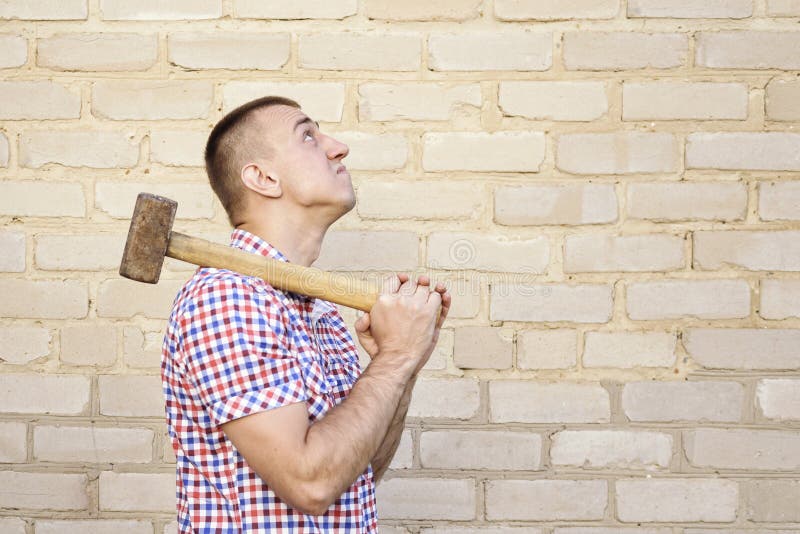 Man with a Hammer on the Shoulder, on the Brick Wall Background. Stock ...