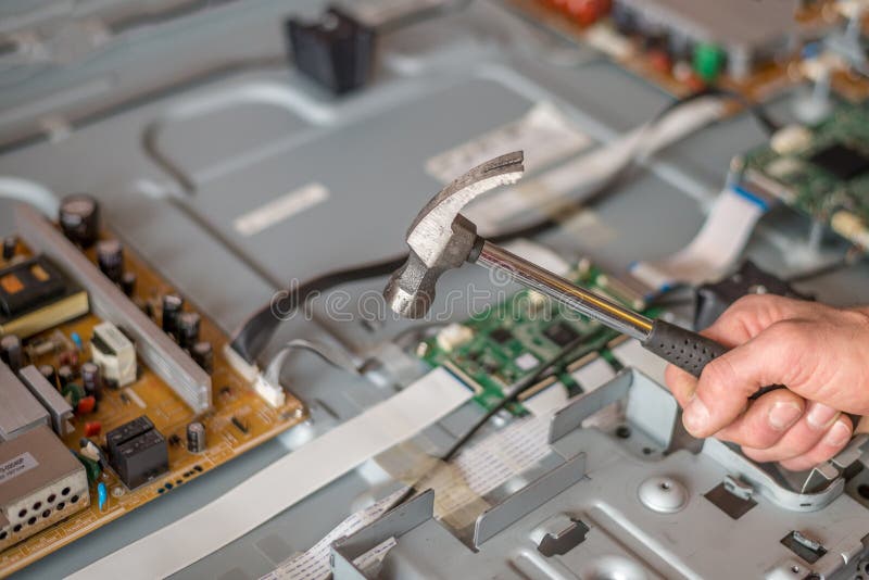 A Man with a Hammer and a Wrench in His Hands is in Front of the TV ...