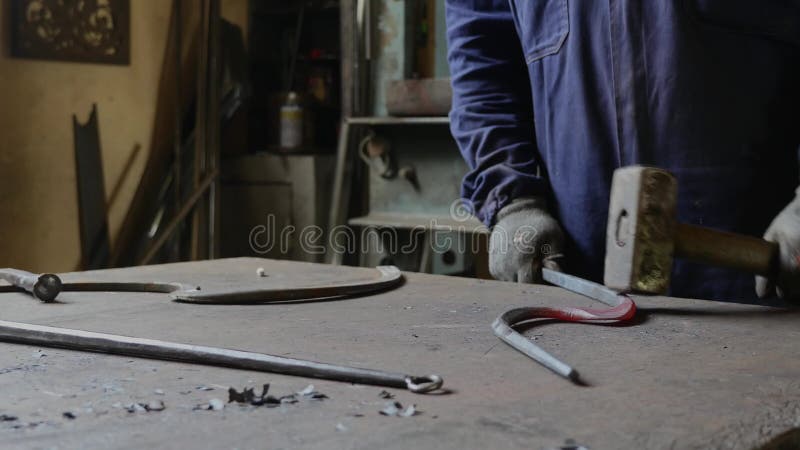 A Man is Hammering an Iron Hook with a Hammer Stock Photo - Image of ...