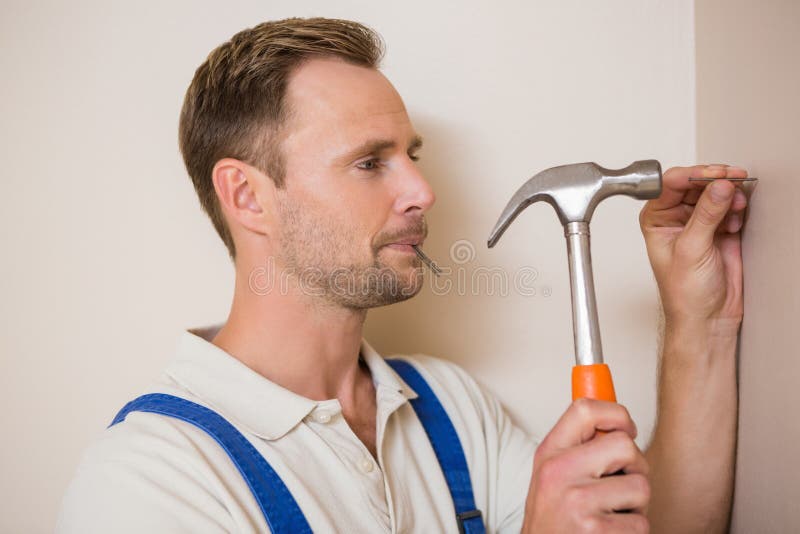 Man Hammering Nail in the Wall Stock Image - Image of sitting, house ...
