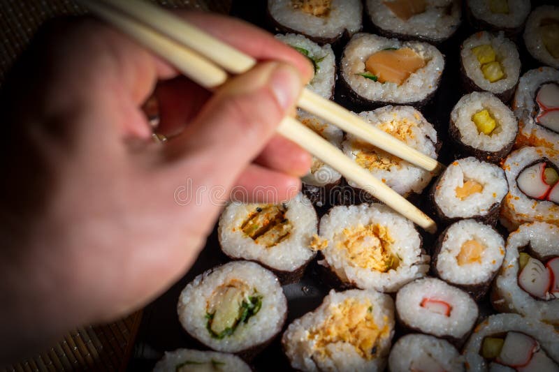 Man Hand with Bamboo Chopsticks Taking Sushi Roll Stock Photo - Image ...