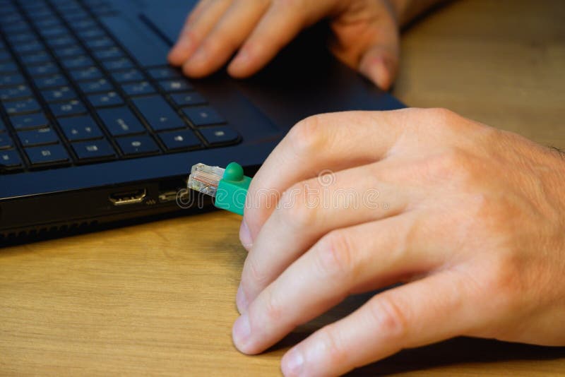 A Man Hand Connects an RJ45 Network Connector To a Laptop Stock Image ...