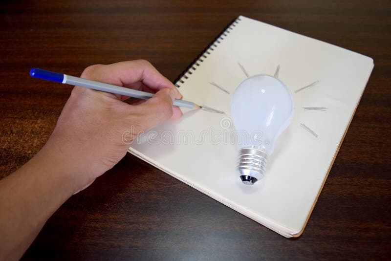 Man Hand Drawing a Light Bulb on Note Paper (idea Concept) Stock Photo ...