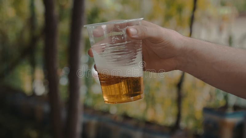 Man Hand Holding and Slow Shaking a Transparent Plastic Cup with Light ...