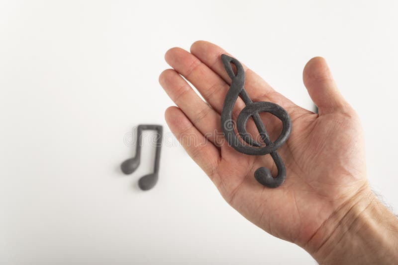 Man Hand Holds Musical Note Treble Clef and Notes Background. Music ...