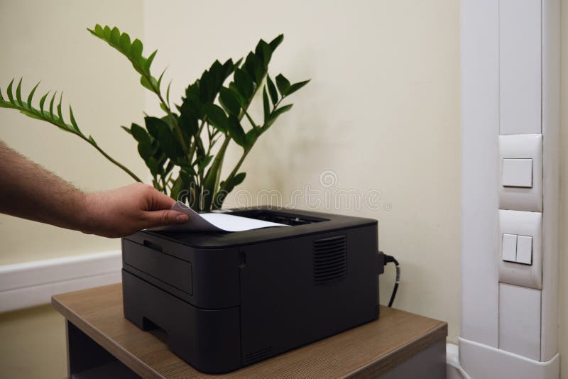 A Man Hand Holds a Sheet of Paper A4 from a Printer in an Office Room ...