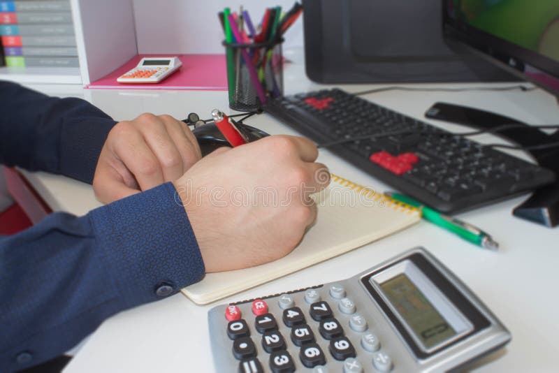 Man Hand with Pen, Calculator and Computer on Wooden Table. he is Using ...