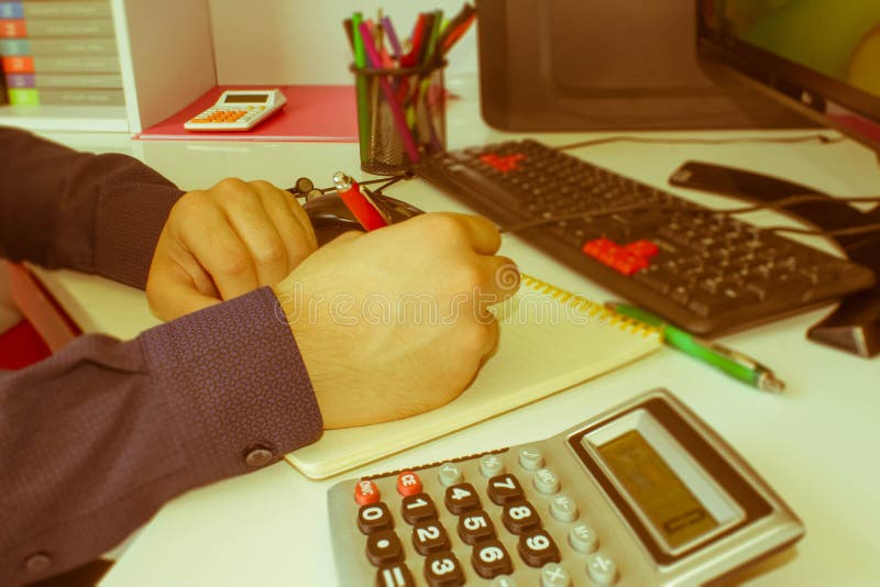 Man Hand with Pen, Calculator and Computer on Wooden Table. he is Using ...
