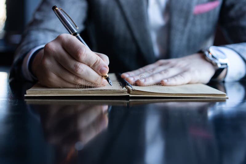 Man Hand with Pen Writing on Notebook on Table. Man Working at Coffee ...