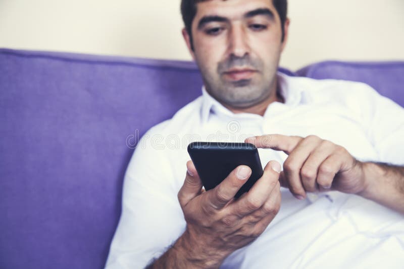 Man hand phone on the sofa stock photo. Image of screen - 161717802