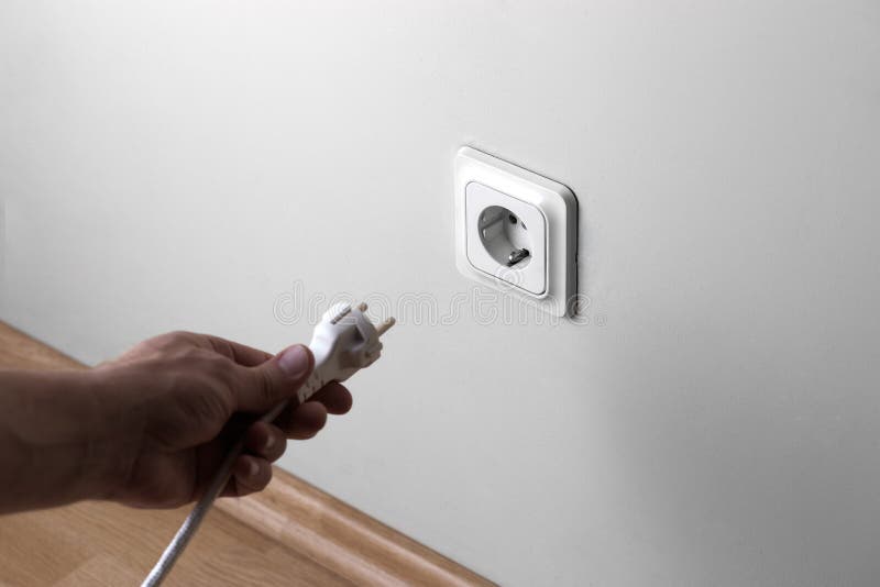 Man Hand Plugging Electric Plug a in a Socket on the Wall Stock Photo ...