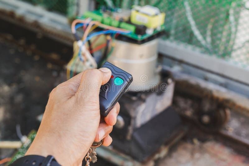 Man Hand Pressing Remote Control To Open Gate Door. Stock Image - Image ...