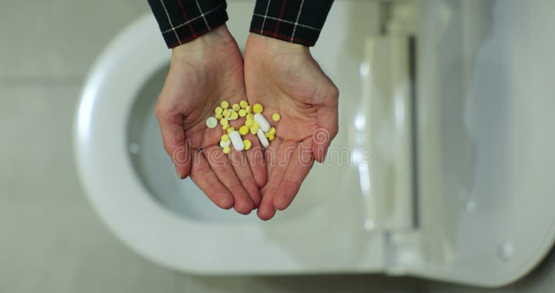 Man Hand Throws Pills into the Toilet for Flushing Water. Close-up ...