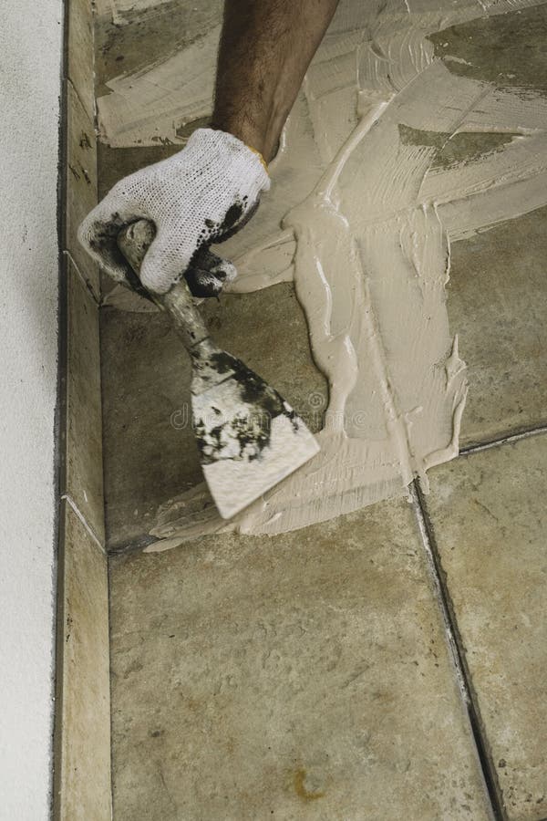 Man Hand with Trowel Plastering a Tiles, Laying Tiles.Construction ...