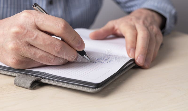 Man Hands Closeup Taking Notes in Planner. Man Sitting at Table in ...