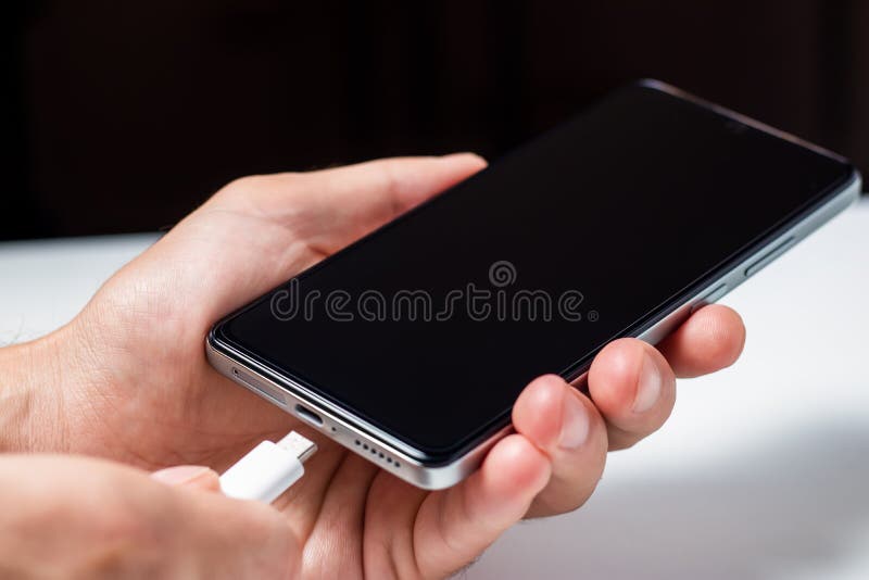Man Hands Plugging a Charger in a Smart Phone. Man Using Smartphone ...