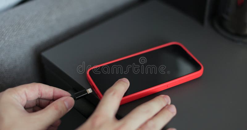 Man Hands Plugging a Charger in a Smartphone on Bedside Table. Mobile ...