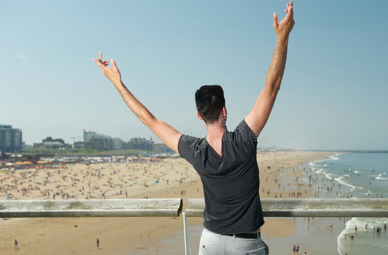 Man with Hands Raised Overlooking Beach with People Stock Photo - Image ...