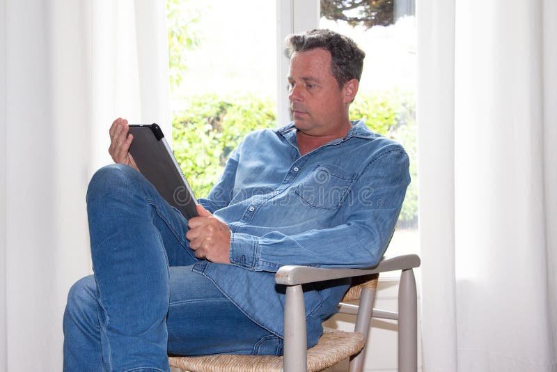 Man Handsome Looking at Digital Tablet Screen at Home Interior Stock ...