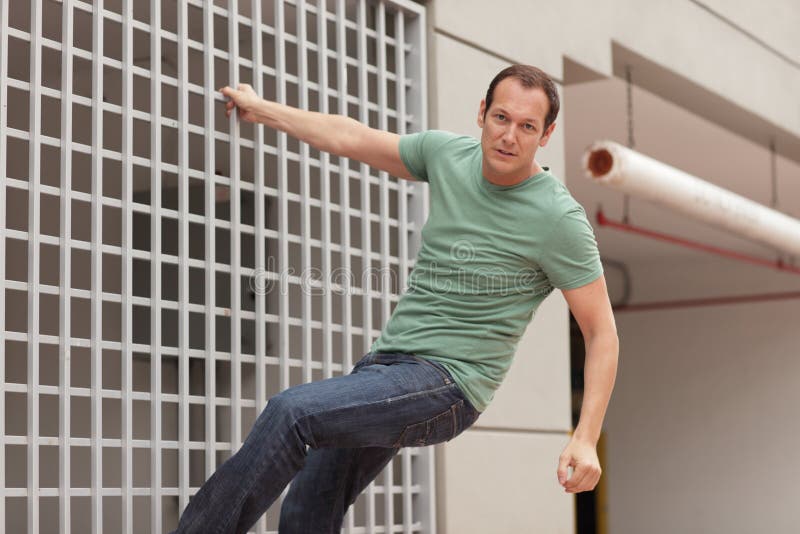 Man Hanging from a Building Stock Image - Image of horizontal, color ...