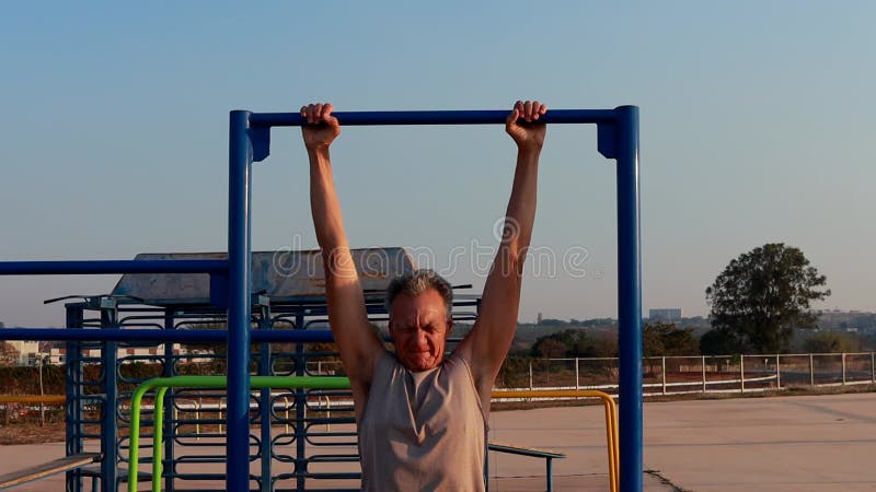 Man Hanging and Stretching from a PullUp Bar for Pain Relief Stock ...