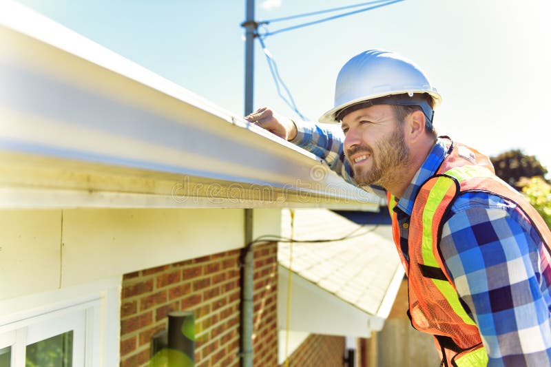 Man with Hard Hat Standing on Steps Inspecting House Roof Stock Photo ...