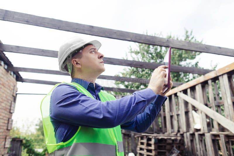 Building Inspector. Man in a Hard Hat and a Yellow Reflective Vest ...