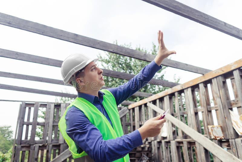 Building Inspector. Man in a Hard Hat and a Yellow Reflective Vest ...