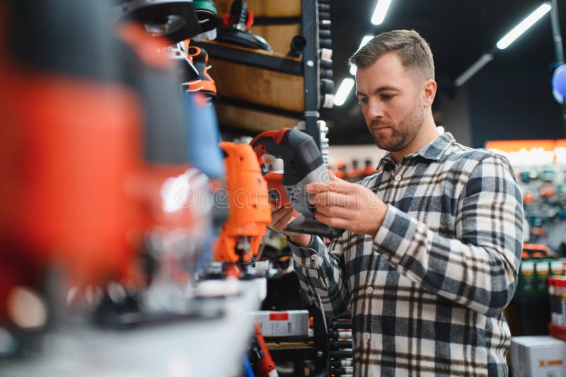 A Man in a Hardware Store Choosing a Tool Stock Photo - Image of items ...