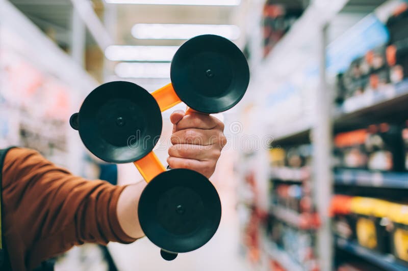 A Man in a Hardware Store Holds a Tool for Removing and Transporting ...