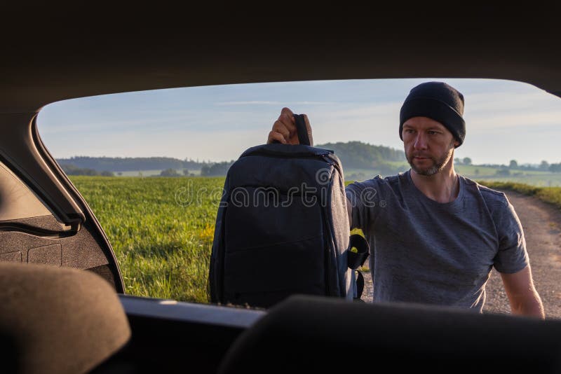 Man in Hat, Traveler Loading Backpack into Car. Travel Concept Stock ...