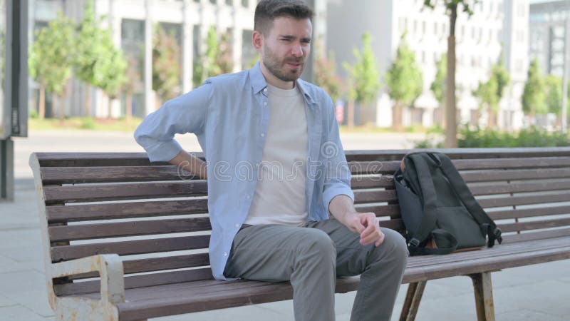 Young Man Having Back Pain while Sitting on Bench Stock Image - Image ...