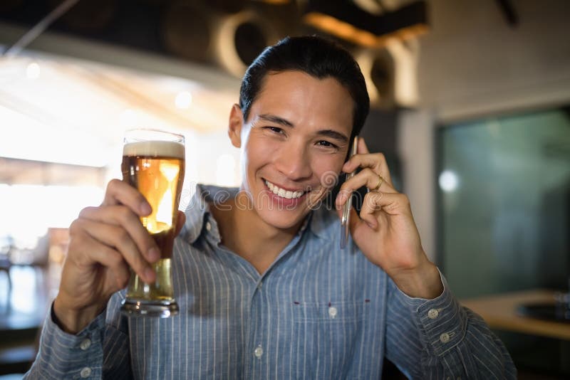 Man Having Beer while Talking on Mobile Phone Stock Image - Image of ...