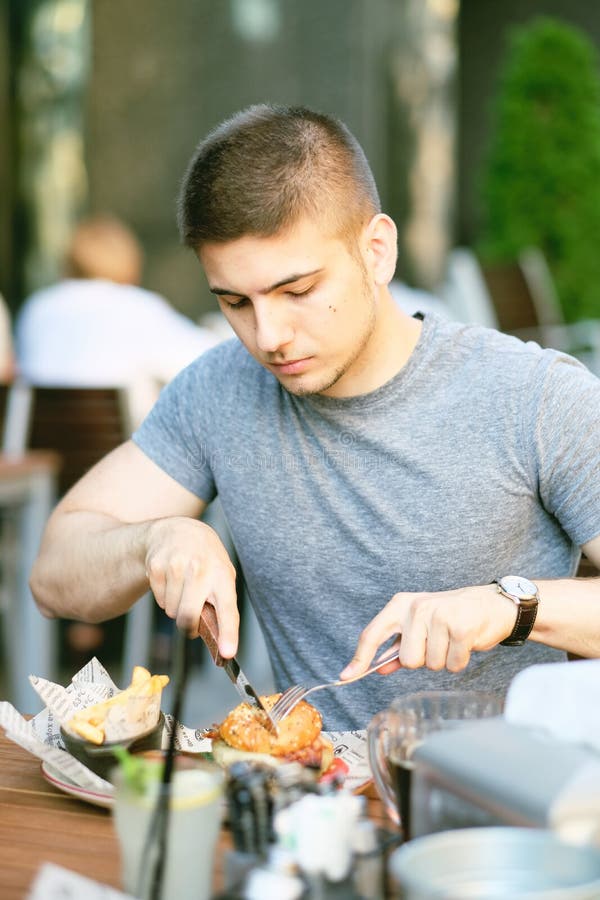 Man Having Cheeseburger in Restaurant Stock Image - Image of meal, beef ...