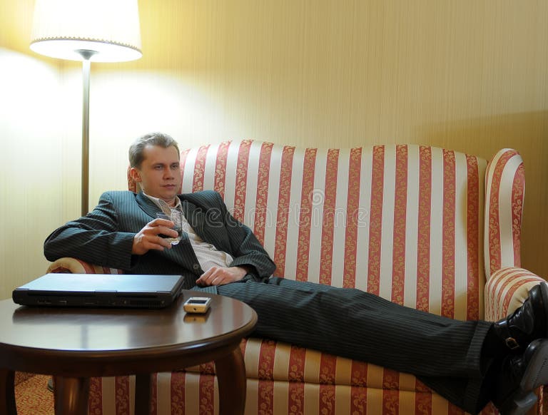 Man having drink on sofa stock photo. Image of reclined - 8450498