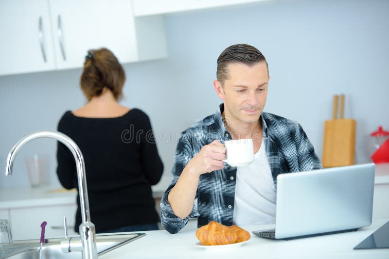 Man Having Snack while Working with Laptop in Kitchen Stock Image ...