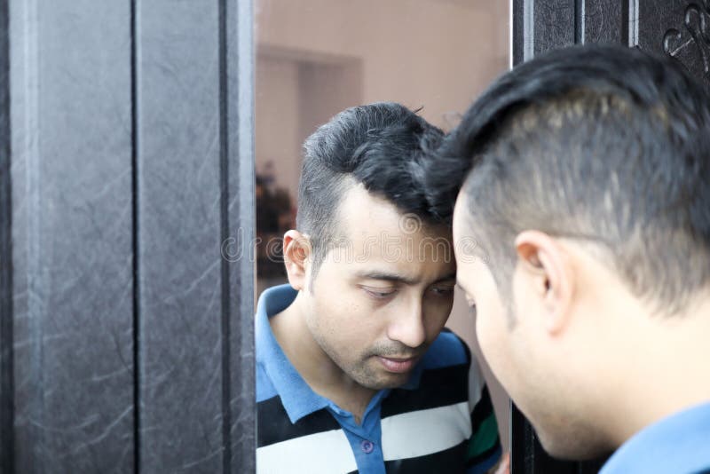 A Man with Head Down in Front of a Mirror in Depressed Mood with ...