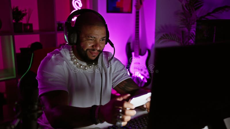 A Man with Headphones Gaming at Night in a Neon-lit Room Smiling at a ...