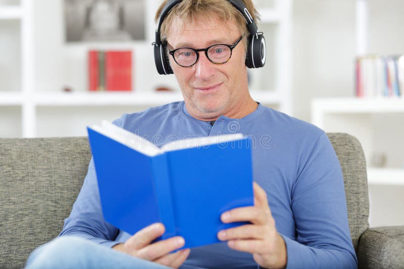 Man with Headphones Listening and Reading at Home Stock Photo - Image ...